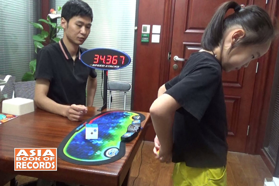 Fastest child to solve two 2×2×2 Rubik’s Cubes with hands behind the ...